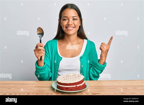 Beautiful Hispanic Woman Eating Carrot Cake Smiling Happy Pointing With Hand And Finger To The
