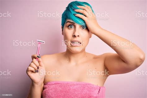 파란색 패션 머리를 가진 젊은 여성은 머리에 손으로 스트레스를 받고 부끄러움과 깜짝 얼굴 분노와 좌절 분홍색 수건을 들고 뷰티