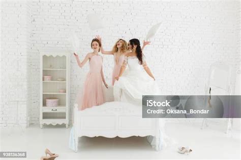 여자는 미쳐가 고 결혼식 전에 침대에 점프 하 고 베개 싸움 흰색 벽돌 벽 배경 3 명에 대한 스톡 사진 및 기타 이미지 3