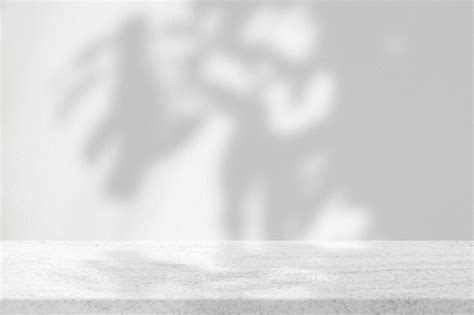 콘크리트 벽 질감 배경에 정원에 나무 그림자가 있는 흰색 대리석 테이블은 제품 프레젠테이션 배경 디스플레이 및 모형에 적합합니다