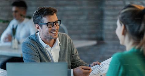 사무실에서 재무 보고서를 살펴보는 동안 동료와 이야기하는 행복한 사업가 사진 Unsplash의 중간 성인 이미지