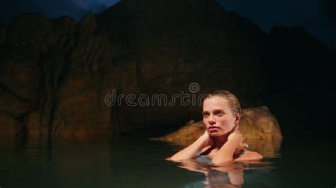 Ethereal Beauty In Blue Dress Immersed In Night Sea Rocks Behind Elegant Lady Enjoys Serene