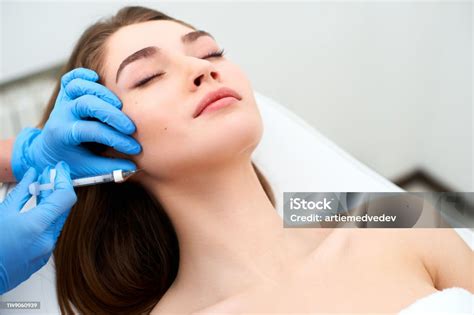 미용사는 필러 주사기로 주사를 만드는 의사 안마사 라인 감소 및 얼굴 윤곽 치료 미용 클리닉에서 안티 에이징 치료 및 얼굴 리프트 의 자에 누워 있는 환자 피부 필러에 대한