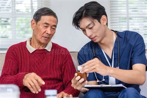 Nurse Explaining Medication Dosage To Elderly Patient During A Home Care Visit Stock Image