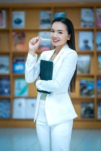 도서관에 서 있는 비즈니스 정장을 입은 쾌활한 아시아 대학 강사의 초상화 45 49세에 대한 스톡 사진 및 기타 이미지 45 49세 개인 지도 교사 교사 교육 관련