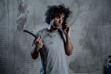 국내 사고 후 전기 케이블을 들고 있는 청년의 초상화는 더러운 탄 재미있는 얼굴 표정으로 도움을 요청하는 휴대 전화로 필사적으로 전화를 걸었다 전기 수리 및 Diy 개념