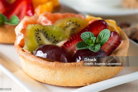 나무 바탕에 설탕을 던져 신선한 과일과 베리 타르트 디저트 라즈베리 포도 딸기 체리 키 위 자 몽과 크림으로 맛 있는 달콤한 케이크 가까운에 대한 스톡 사진 및 기타 이미지