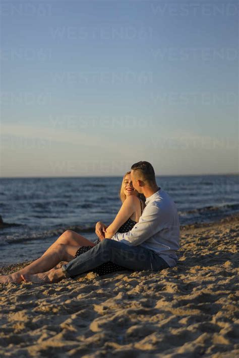 Junges Paar Sitzt Zusammen Am Strand Lizenzfreies Stockfoto