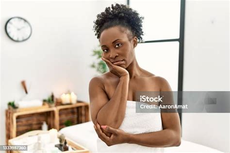 미용 센터에 서 수건을 입고 젊은 아프리카 계 미국인 여자 는 지치고 교차 팔에 우울증 문제로 지루해 보이는 생각 건강한 생활방식에 대한 스톡 사진 및 기타 이미지 Istock