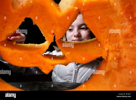 Girl Carves A Face Into A Pumpkin For Halloween Stock Photo Alamy