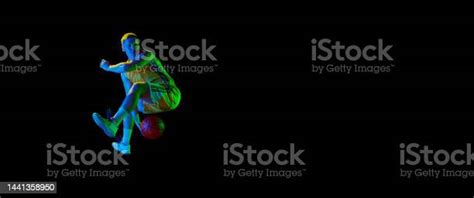 젊은 활동적인 운동 선수 공을 가지고 연습하는 스포츠 유니폼을 입은 남자 농구 선수의 역동적인 초상화 점프 네온 불빛의 어두운 배경 위에 고립된 드리블 20 24세에 대한