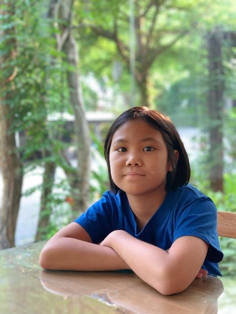 Premium Photo Portrait Of Girl Sitting At Table