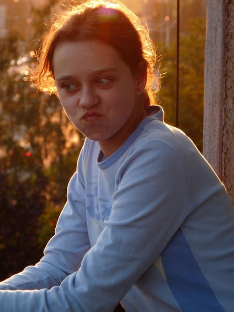 Premium Photo Girl Making Face While Sitting Outdoors