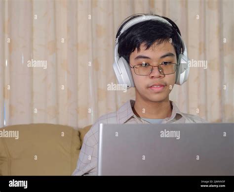 Preteen Schoolboy Wearing Headphone To Learning Online Watching Class