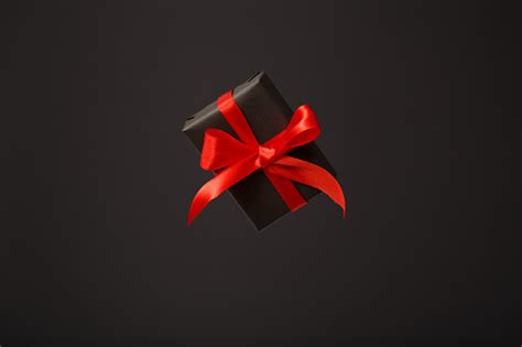 검은 색 배경에 공기에 떠있는 빨간 활과 비행 검은 선물 상자에 놀라움 블랙 프라이데이 세일 크리스마스 세일 할인 컨셉 발렌타인 데이 아버지의 날 0명에 대한 스톡 사진 및
