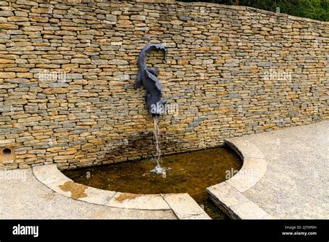 A Cast Metal Newt Water Feature On A Wall Of Cotswold Stone At The