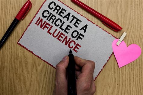 영향의 A 서클 만들기를 보여주는 텍스트 기호 개념 사진 Influencer 리더 동기를 부여 다른 사람들 글 스티커 메모 클립 핀치 심장 손 잡고 마커 빨간 펜 나무