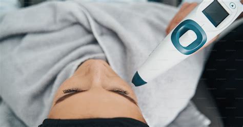 Co2 메조테라피 총으로 얼굴 리프팅 절차를 받고 있는 백인 여성 환자의 상위 뷰 사진 Unsplash의 성인 이미지