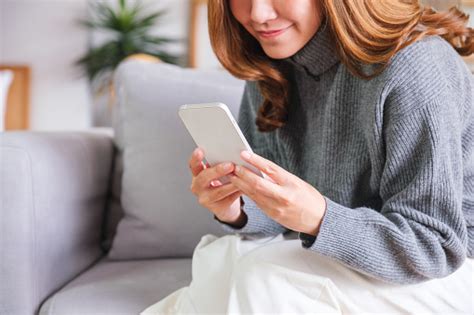 집에서 스마트폰을 들고 사용하는 젊은 여성의 근접 촬영 이미지 Brand Name Online Messaging Platform