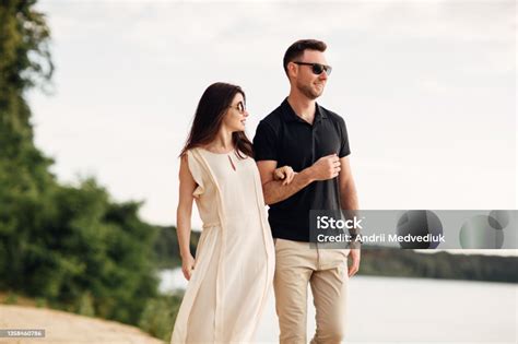 호수 근처 해변에서 행복한 연인 젊은 부부는 손을 잡고 여름 날 야외에서 걷고 있습니다 사랑에 빠진 남자와 여자 사랑과 가족의 개념 전체 길이 닫습니다 전단지에 대한 스톡