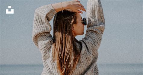 흰색 스웨터와 파란색 데님 청바지를 입은 여자가 낮 동안 해변 해변에 서 있다 사진 Unsplash의 무료 배경화면 이미지