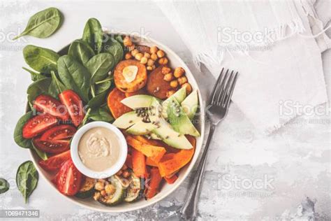 채식주의와 구운된 야채 Chickpeas 아보카도 흰색 배경에 평면도 Tahini 드레싱 샐러드 그릇 건강한 생활방식에 대한