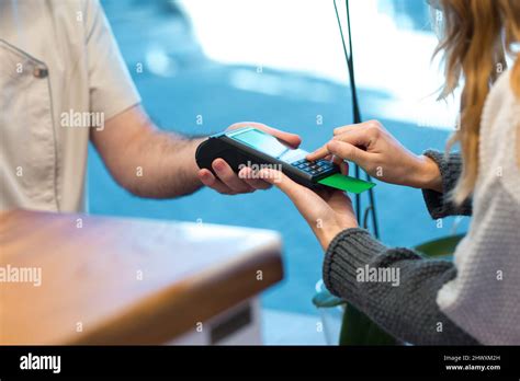 Woman Entering Bank Card Code On Swiping Machine In Clinic Stock Photo Alamy