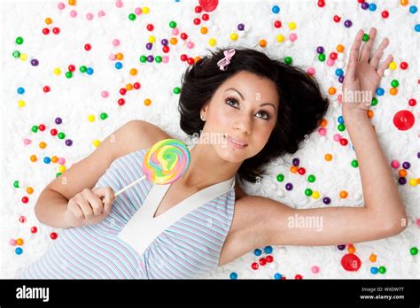 Young Latina Woman Laying On Ruffled Cloud Like Floor Between Colorful