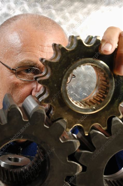 Engineer Scrutinising Metal Cogs Stock Image F018 0914 Science Photo Library