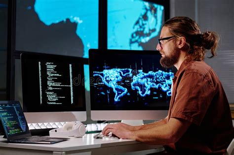 Side View Of Young Serious Male Programmer Decoding Data On Computer
