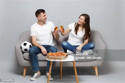 웃 고 있는 커플 여자 남자 축구 팬 응원 축구 공 회색 벽 배경에 고립 된 맥주 병을 들고 좋아하는 팀 지원 사람들의 감정 스포츠 가족 레저 라이프 스타일 개념입니다