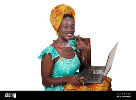 A Beautiful African Businesswoman In Traditional Dress Sitting On A