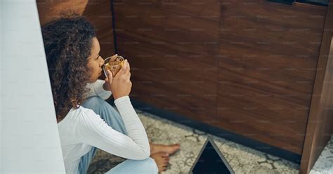 부엌 바닥에 앉아 캐주얼 옷을 입은 진지한 젊은 곱슬머리 아프리카계 미국인 여성 사진 Unsplash의 차 뜨거운 음료 이미지