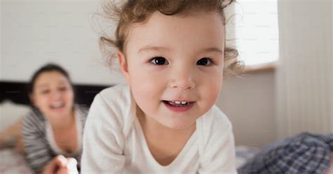 귀여운 딸이 침대에 누워 즐거운 시간을 보내는 아름다운 젊은 엄마 사진 Unsplash의 크롤링 이미지