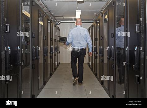 System Administrator At Work In A Company Server Room Walking Away