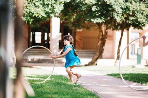 Free Photo Girl Rolling Hula Hoop On Grass