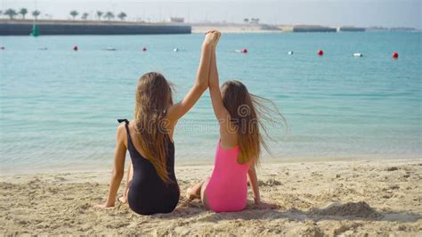 Two Little Happy Girls Have A Lot Of Fun At Tropical Beach Playing