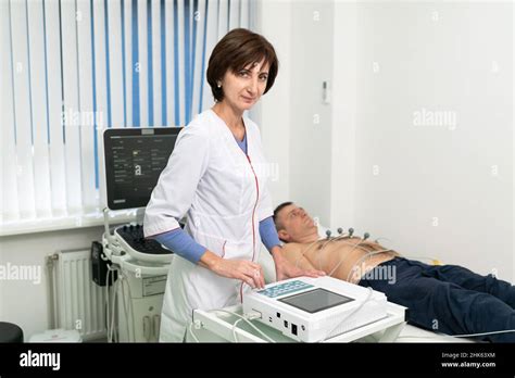Cardiologist Doctor Performs Electrocardiography Procedure On Man Lying