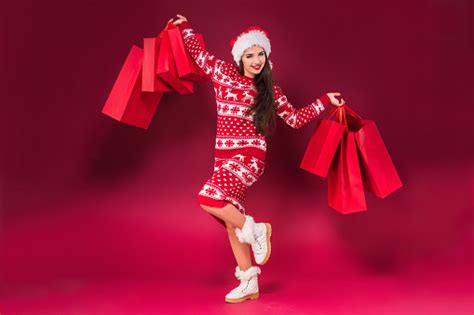 매력적인 여자는 그녀의 양손으로 구입된 선물의 많은 패키지를 들고 있다 젊은 여 자가 서 서 웃 고 가방에 대한 스톡 사진 및 기타 이미지 Istock