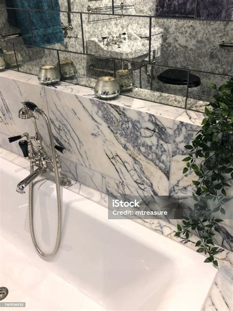 흰색 회색 대리석 벽과 바닥 타일 흰색 세라믹 욕조 싱크대 화장실 스테인레스 스틸 빅토리아 믹서 탭 및 샤워 배관 인공 후행 식물 거울 수건 레일 타일 바닥 바닥이있는 고급