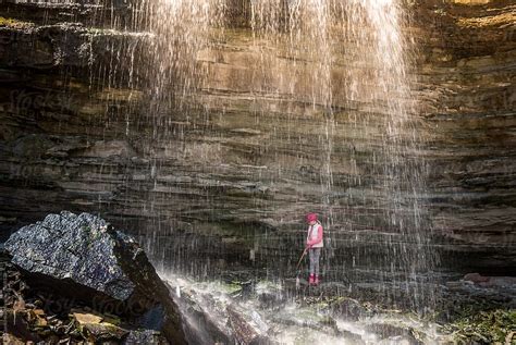 Girl Alone Has Fun Exploring And Getting Wet In Waterfall Cascade By Stocksy Contributor JP