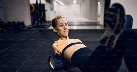 체육관에서 스포츠 훈련을 위해 워밍업하는 폼 롤러를 사용하는 장애가 있는 동기 부여 운동 선수 사진 Unsplash의 체육관 여자 이미지