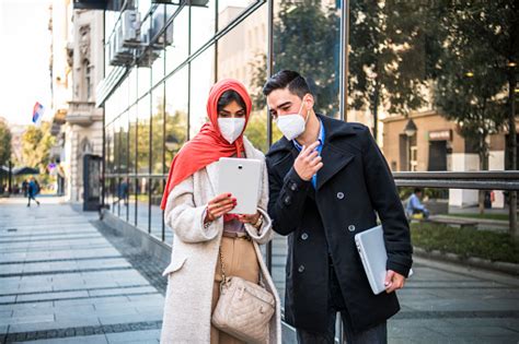 비즈니스 맨과 얼굴 마스크를 가진 무슬림 여성은 디지털 태블릿과 몇 가지 정보를 공유하면서 도시 거리에 서서 이야기 25 29세에 대한 스톡 사진 및 기타 이미지 Istock