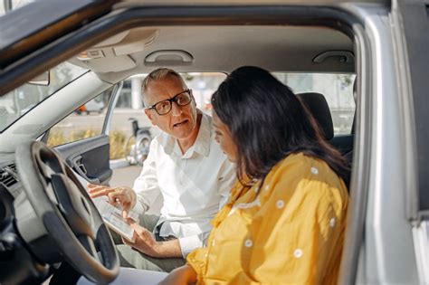자동차의 다양한 기능을 설명하는 강사와 함께 운전 수업을 받는 젊은 여자 20 24세에 대한 스톡 사진 및 기타 이미지 20