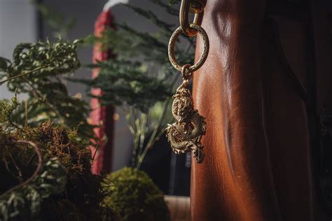 가방 가죽 가방 갈색 가죽 거친 금 금속 금속 녹지 높은 독특한 드래곤 엠블럼 디테일 럭셔리 럭셔리한 문화 변하기 쉬운 복잡한 부자 빈티지