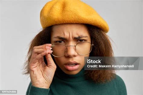 어두운 머리 여자 안경 뭔가 불만된을 통해 모습을 면밀히 감시 되니까요 화가 핑크 배경 위에 포즈 부정적인 감정 표현 눈을 가늘게 뜨고 보기에 대한 스톡 사진 및 기타