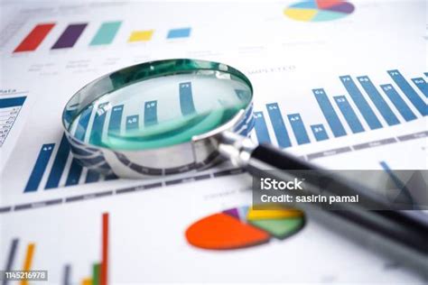 차트에 돋보기 그래프 스프레드 시트 종이 금융 개발 은행 계좌 통계 투자 분석 연구 데이터 경제 증권 거래소 거래 비즈니스 사무실 회사 회의 개념 개발에 대한 스톡 사진 및