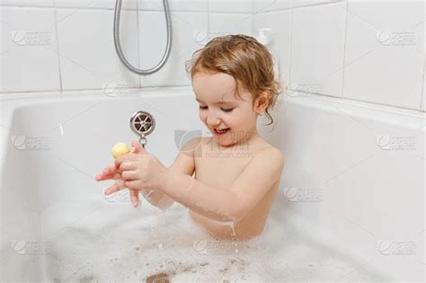 儿童身体护理和卫生。在泡沫中沐浴的小女孩。在浴缸里玩玩具的孩子素材 花瓣网