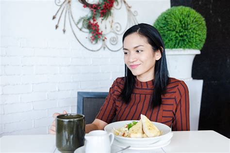 그녀의 앉아에서 멀리 보면서 카페에서 커피 한 잔을 즐기는 젊은 아름 다운 아시아 여자 20 29세에 대한 스톡 사진 및 기타 이미지 20 29세 Capital