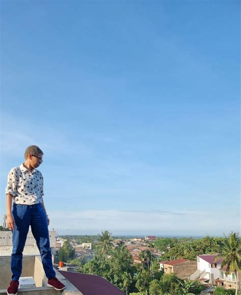 스케이트보드를 들고 지붕 위에 서 있는 남자 사진 Unsplash의 무료 바지 이미지